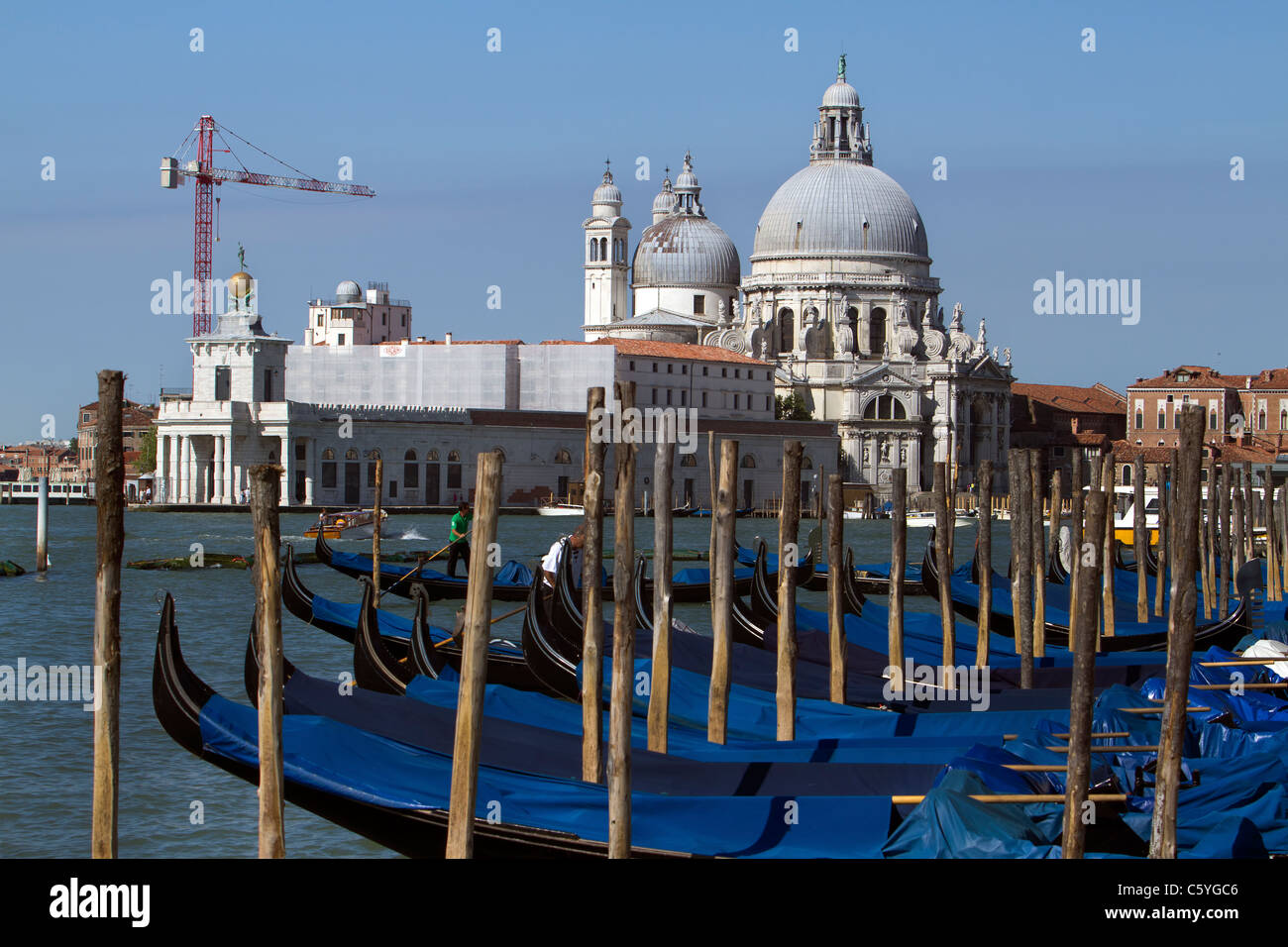 Gondolas moored among piers highlighting Saint Marks Basilica in Venice ...