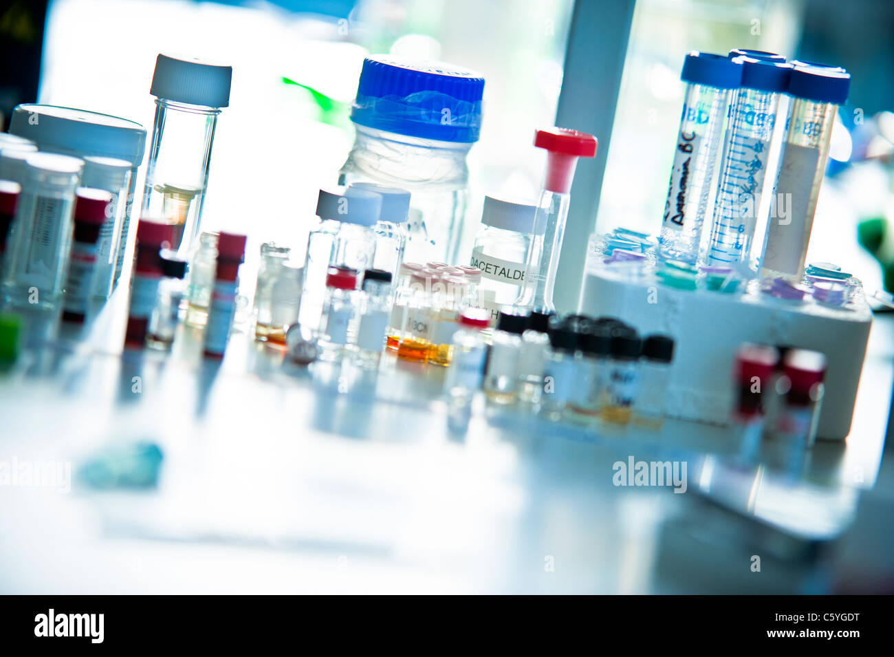 glass test tubes with colored tops on bench side in science laboratory ...