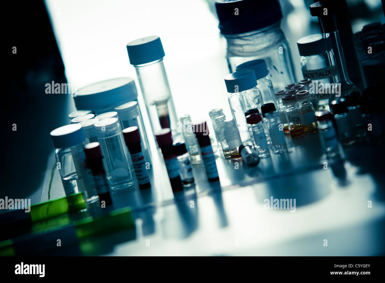 glass test tubes with colored tops on bench side in science laboratory ...