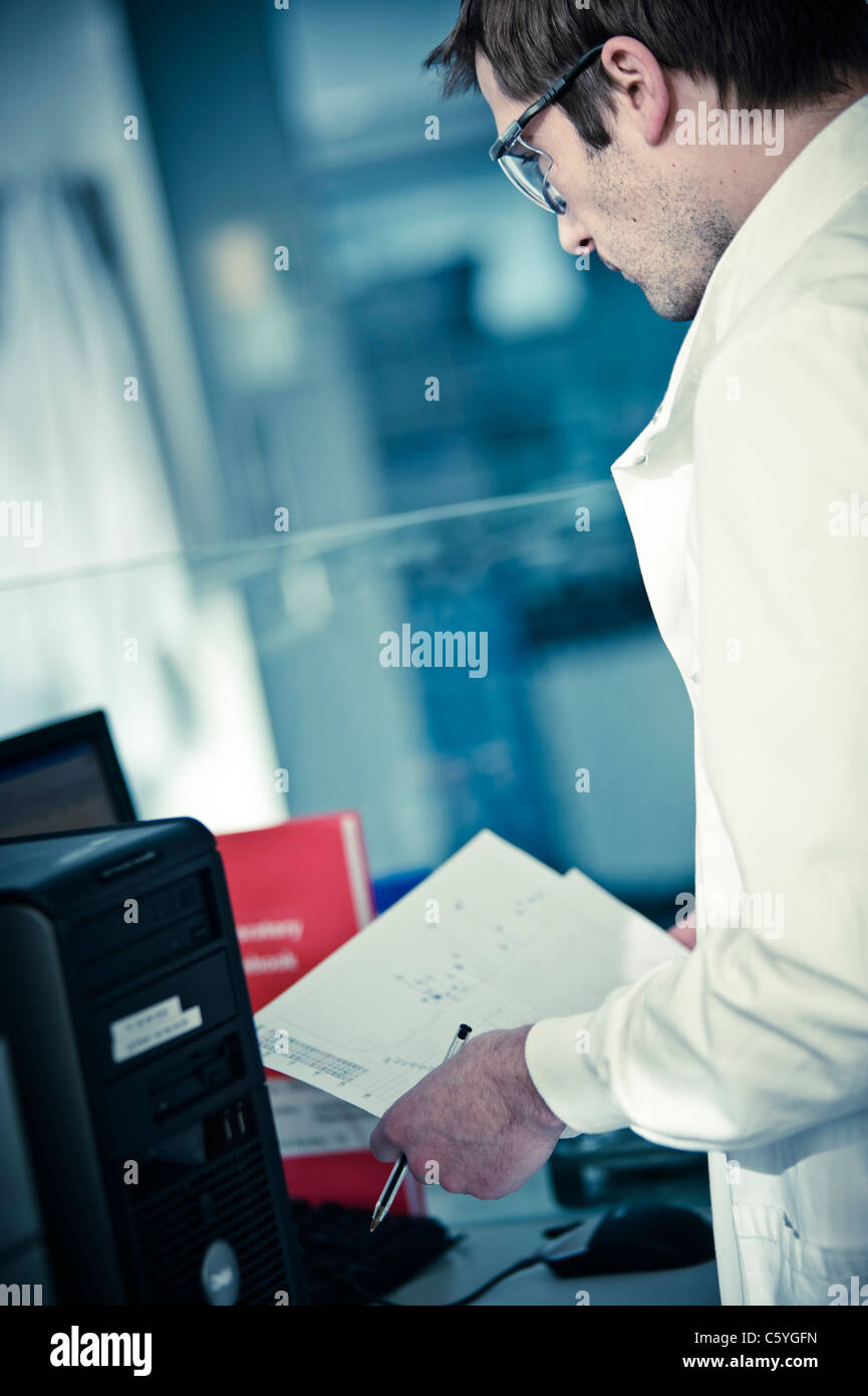 young male scientist wearing goggles and white lab coat in science ...