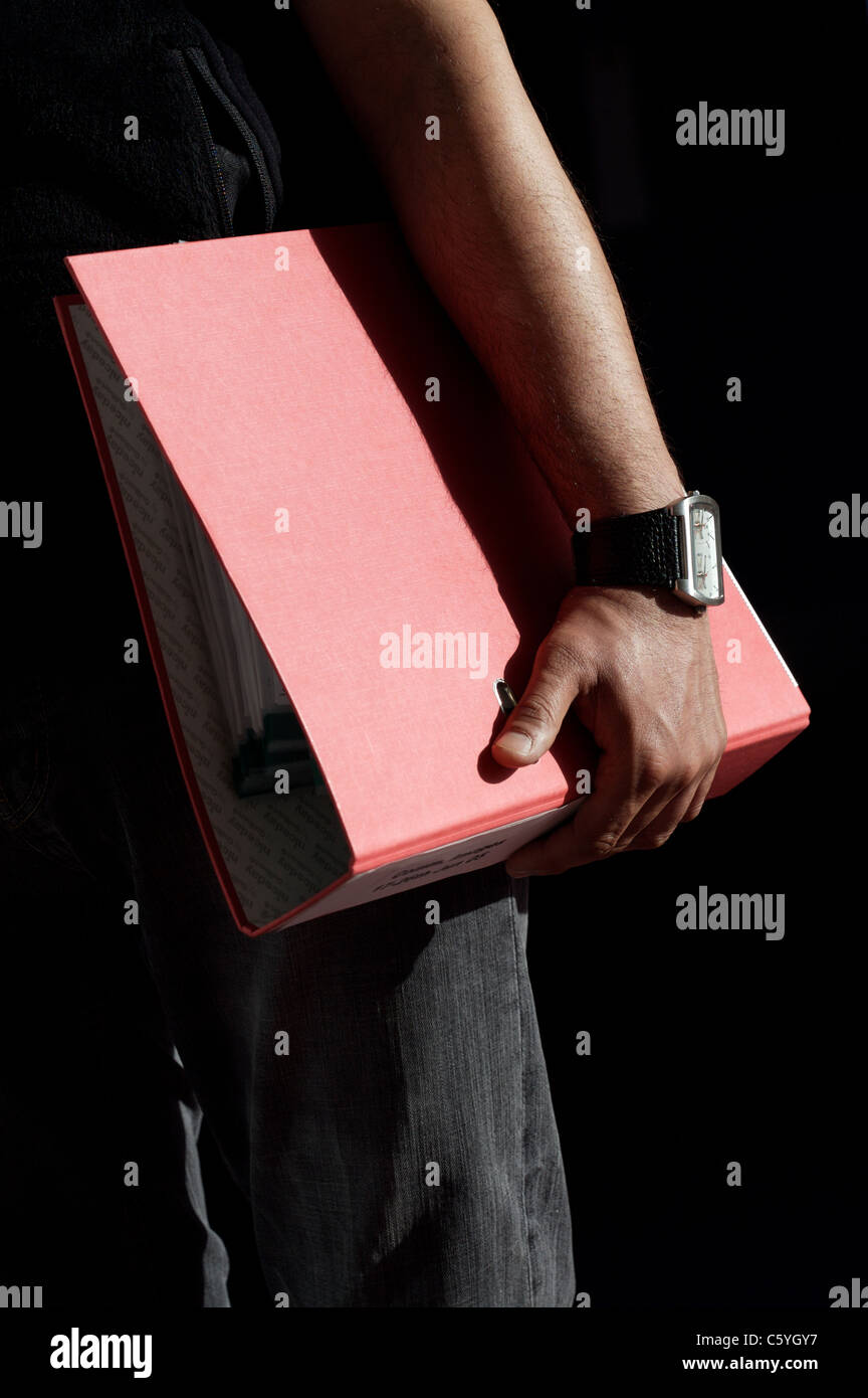Male holding an A4 red ring binder folder in his left hand Stock Photo ...