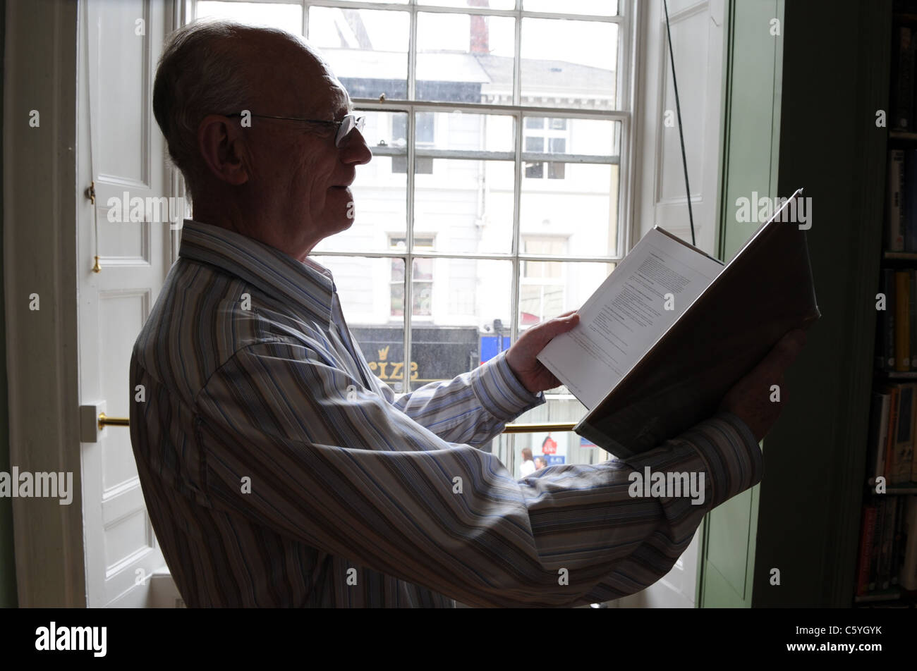 Gentleman standing up reading a book Stock Photo - Alamy