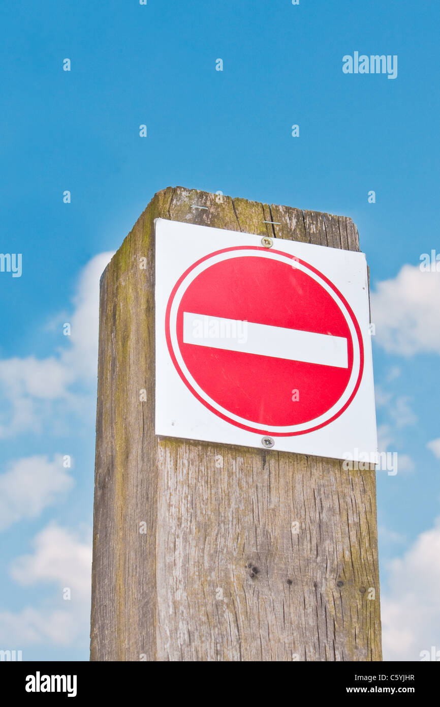 A red no entry sign against a bright blue sky Stock Photo - Alamy