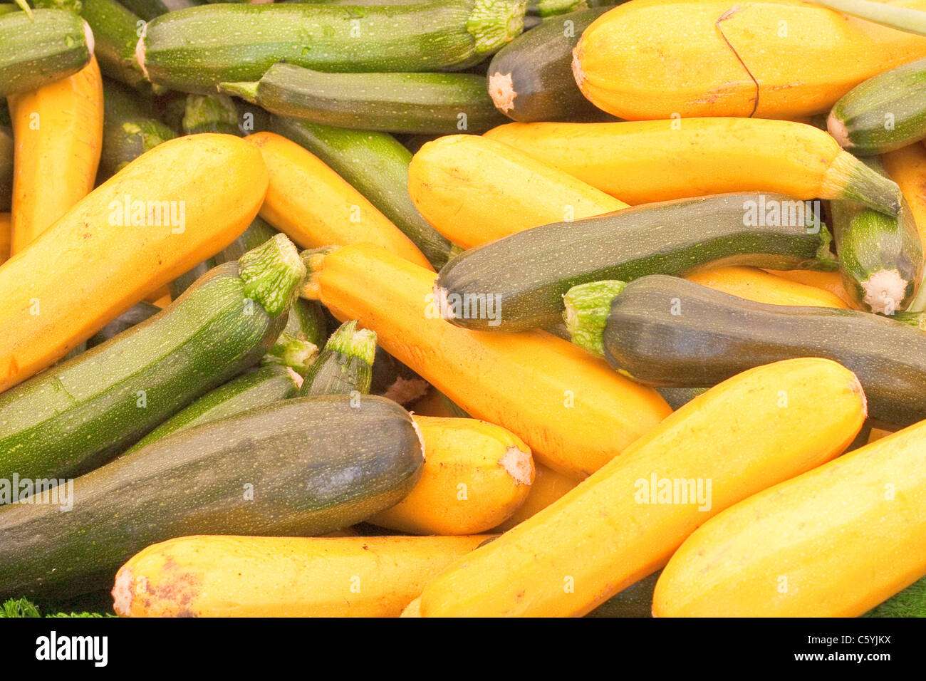 Mixed yellow and green courgettes as a background image Stock Photo - Alamy