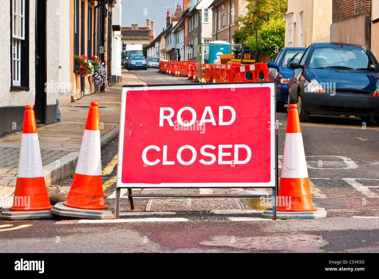 A sign indicating a closed road with traffic cones in an english town ...