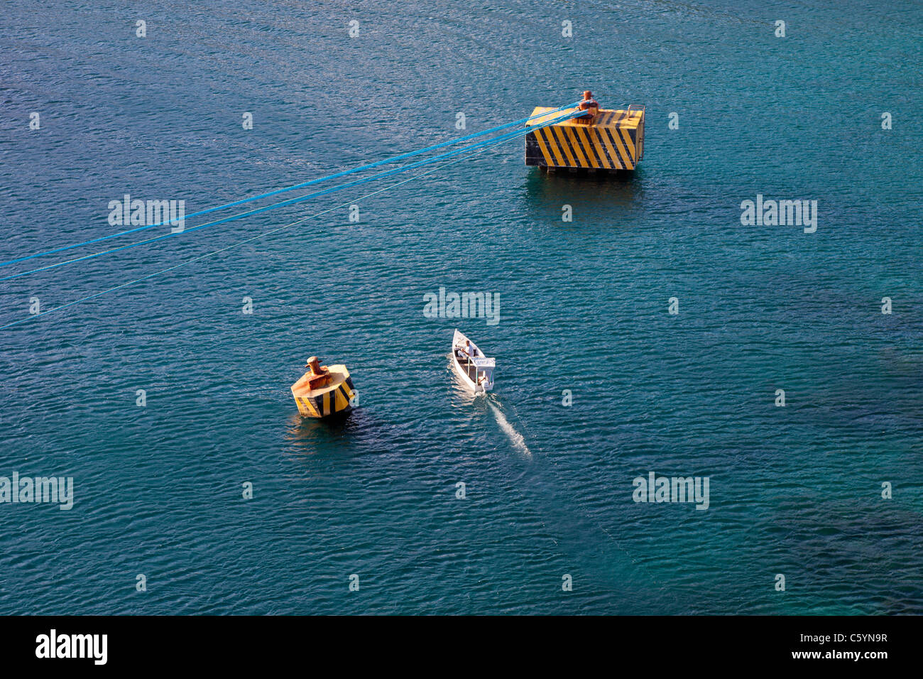 Small boat passes under mooring lines between mooring blocks at cruise ...