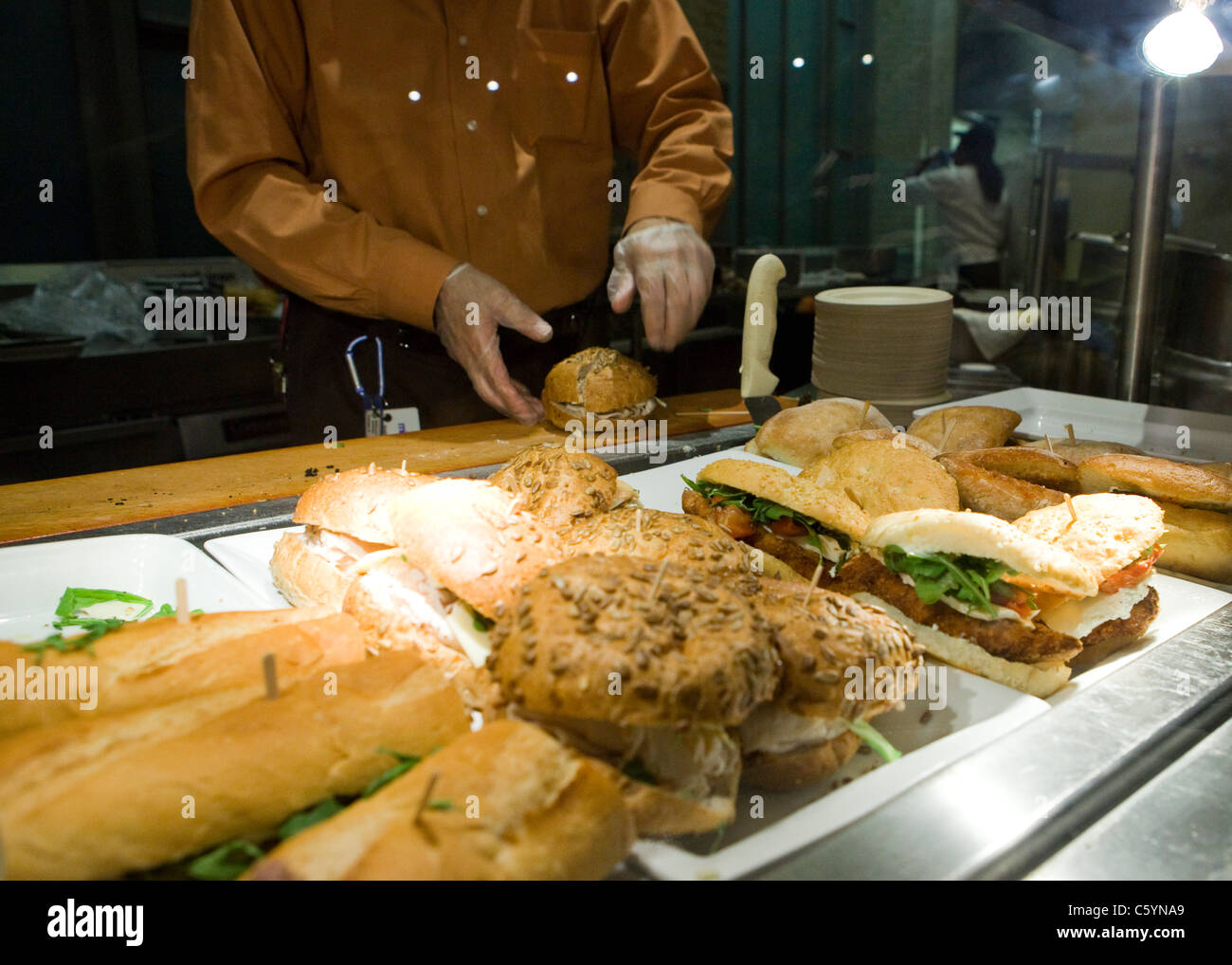 Cook preparing sandwiches behind cafeteria counter Stock Photo - Alamy