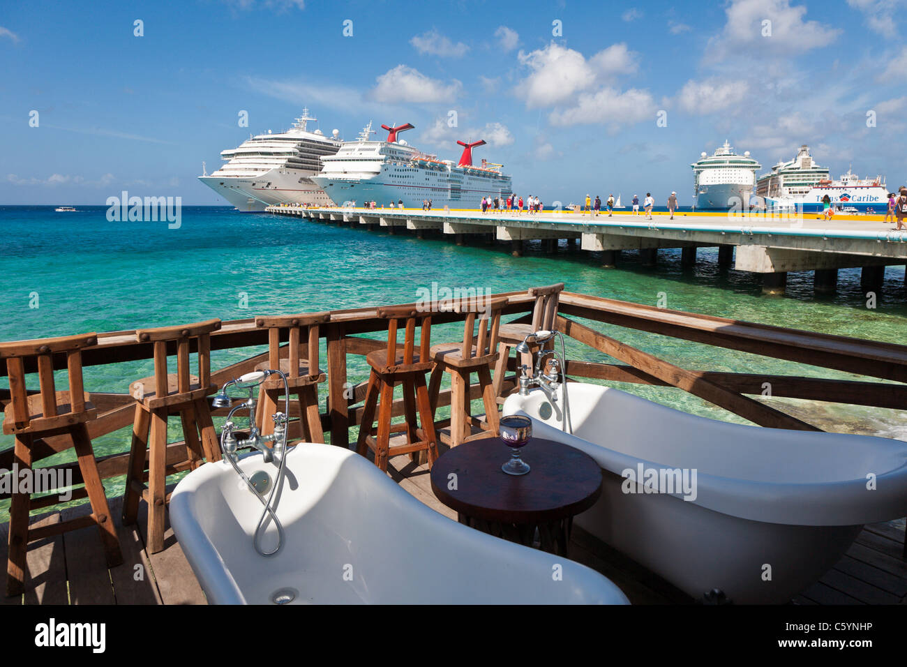 Outdoor bath tubs on wooden deck overlooking cruise ship port at Three ...