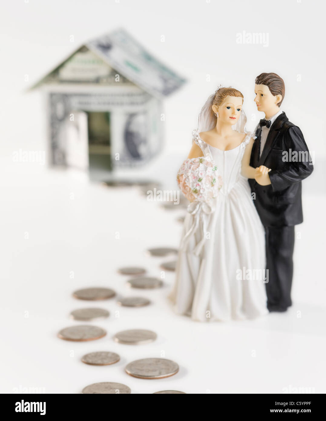 Bride and groom on money path near banknote house Stock Photo - Alamy