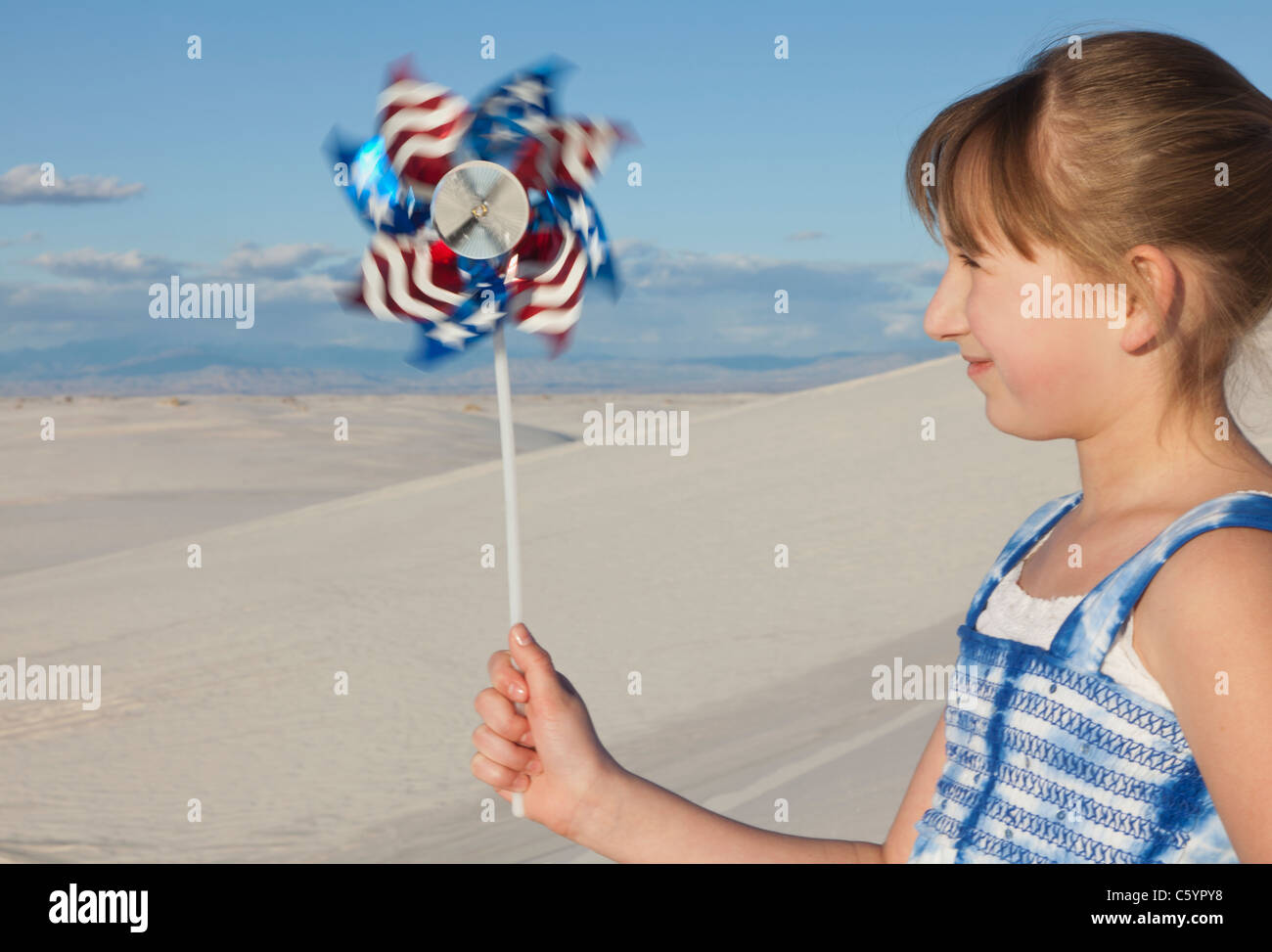 USA, New Mexico, Whitesands, Girl (10-11) on desert holding pinwheel ...