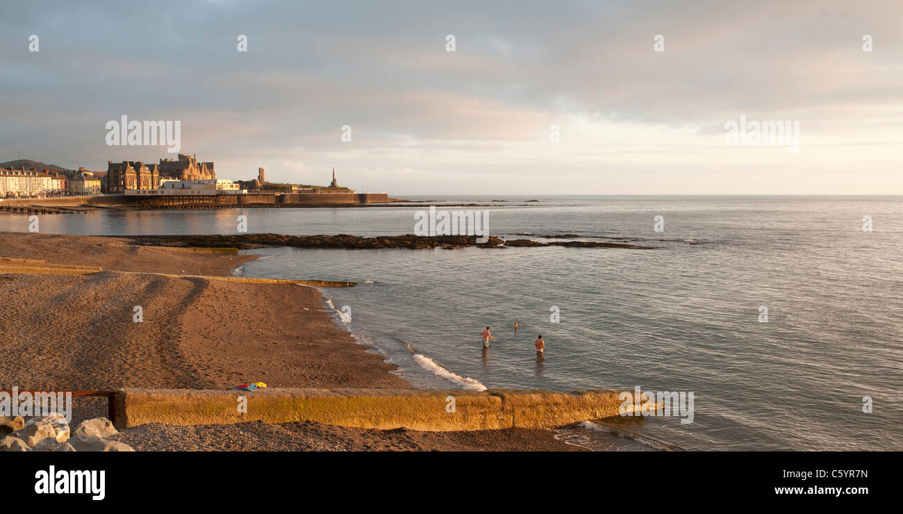 summer evening , people swimming in the sea off Aberystwyth beach Wales ...