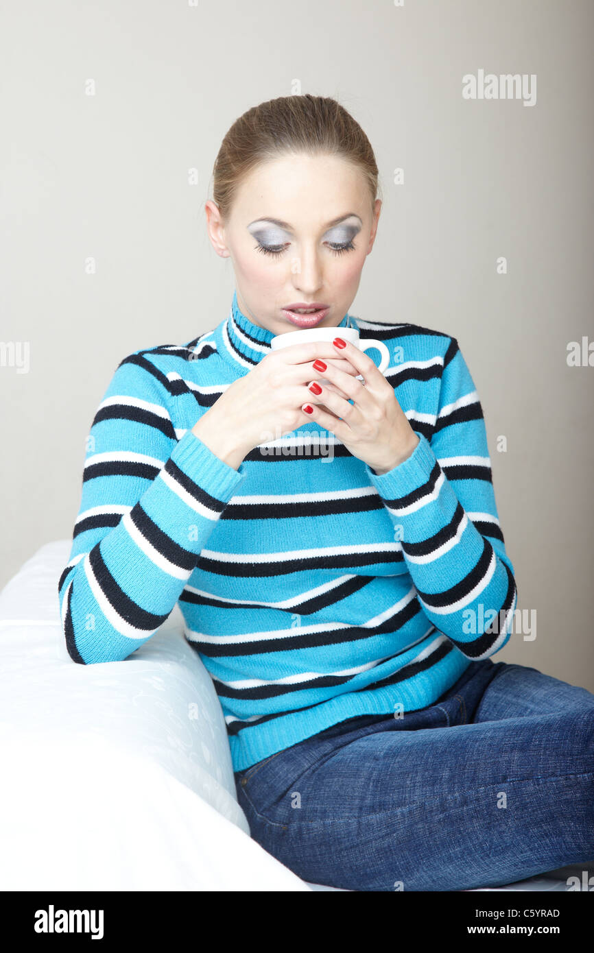 Sick woman drinking hot tea. Indoors photo Stock Photo - Alamy