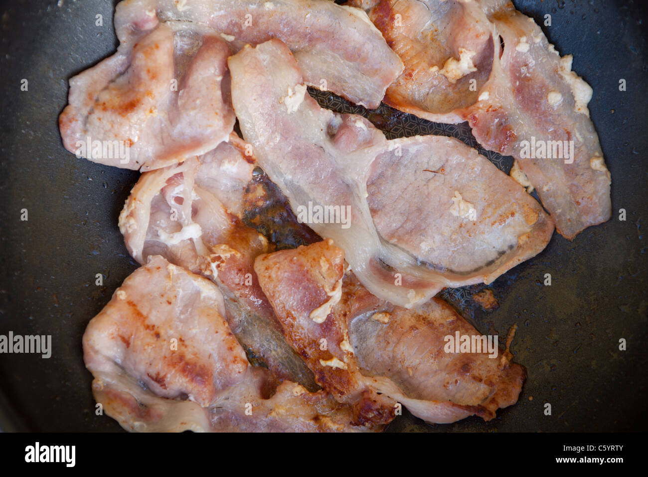 Bacon cooking in a frying pan Stock Photo - Alamy