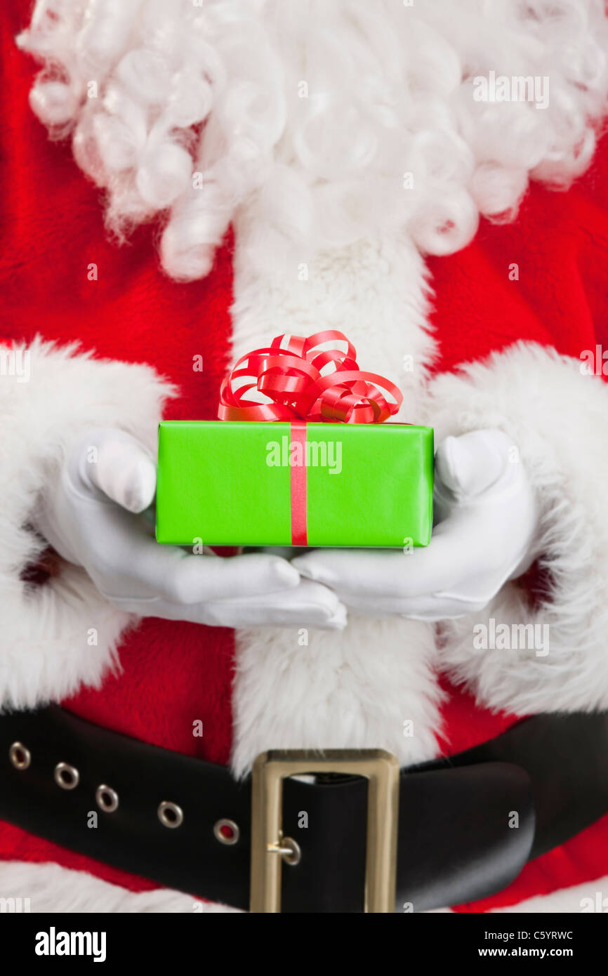 Santa clause holding Christmas gift Stock Photo - Alamy