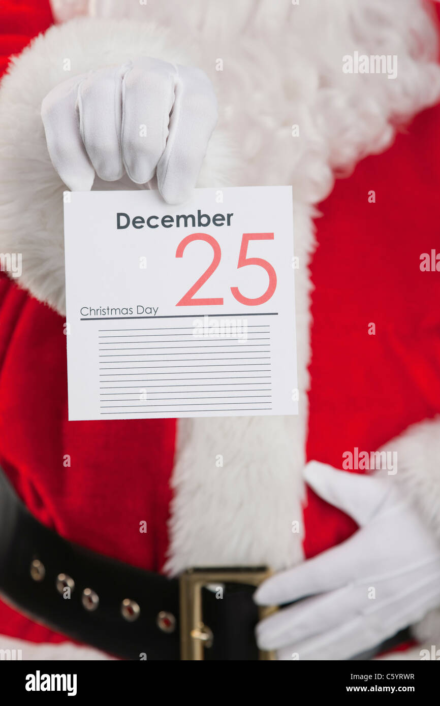Santa clause holding calendar showing Christmas day Stock Photo - Alamy