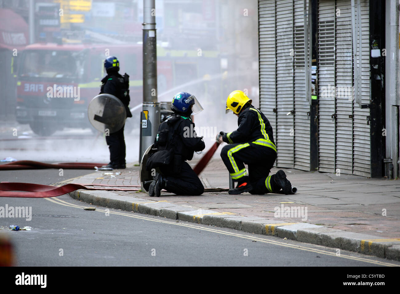 Riot police assist fire crews during a riot in Peckham South London ...