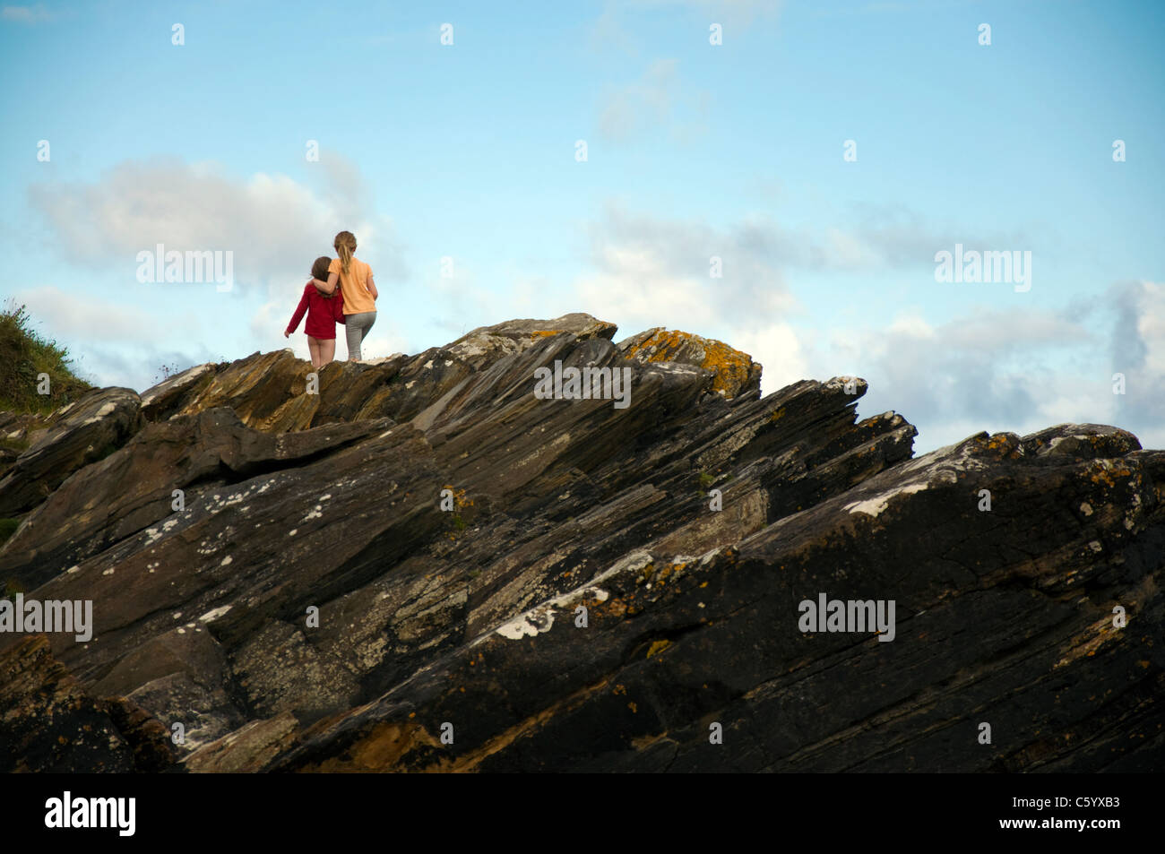 Young children look out from rocks Stock Photo - Alamy