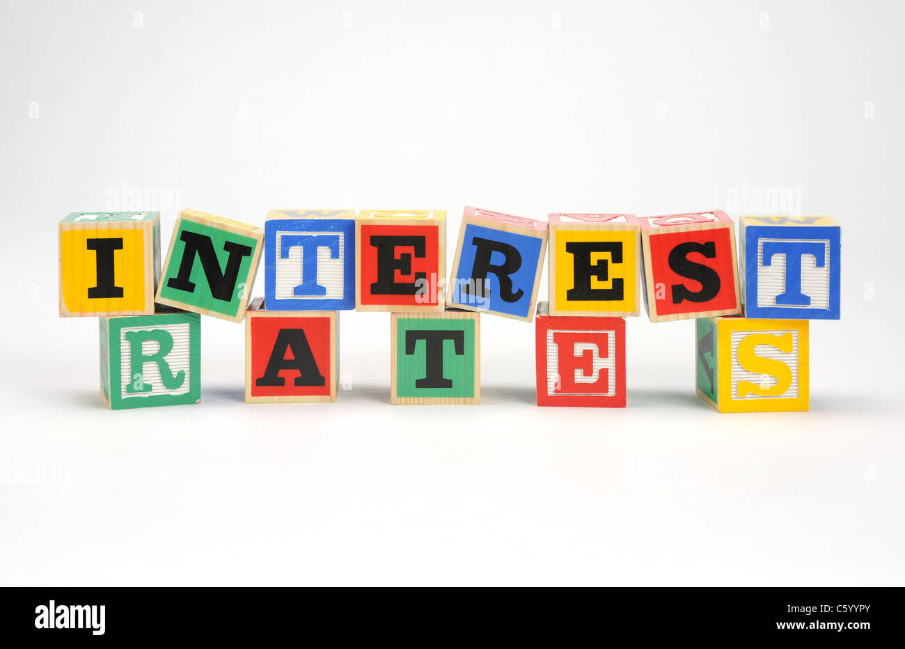 the words 'interest rates' spelled out with children's letter blocks ...