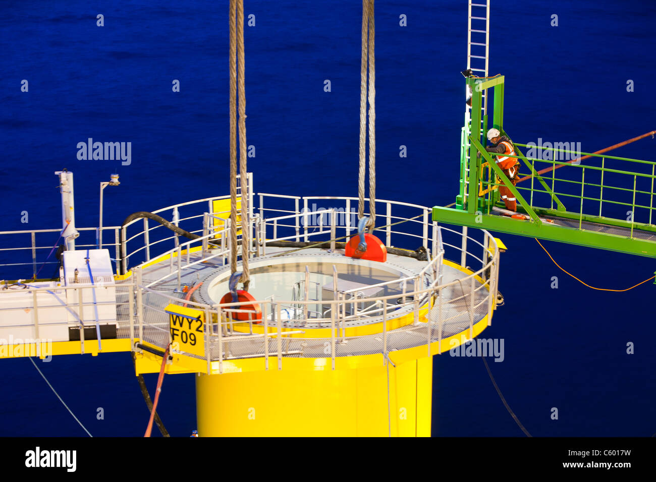workers fixing a transition piece into place on the Walney offshore ...