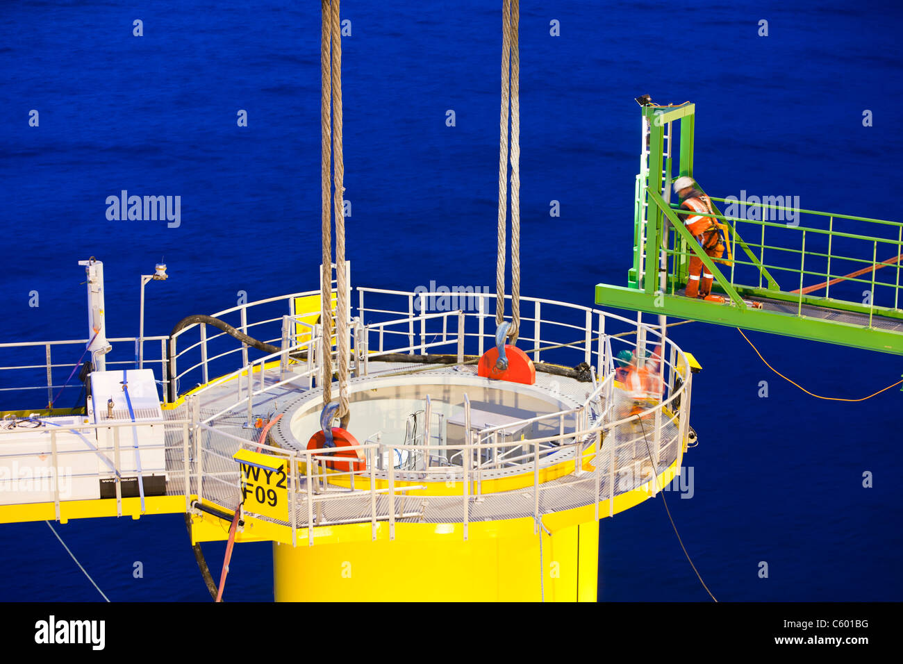 workers fixing a transition piece into place on the Walney offshore ...