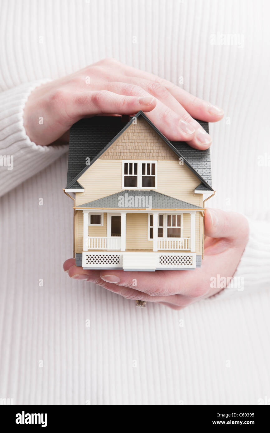 Close up of woman's hands holding model house Stock Photo - Alamy