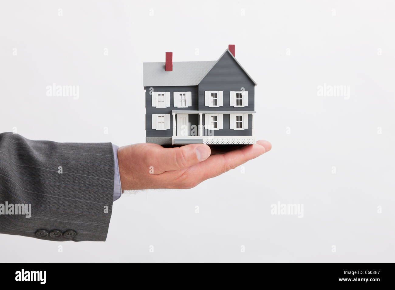 Close up of man's hand holding model house Stock Photo - Alamy