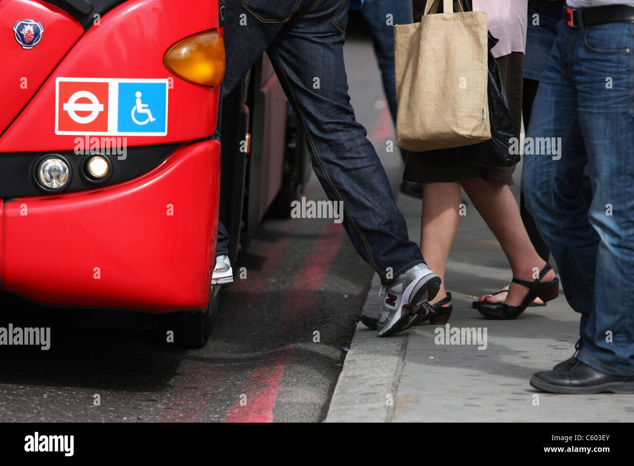 A queue of people boarding a red London bus at a bus stop Stock Photo ...