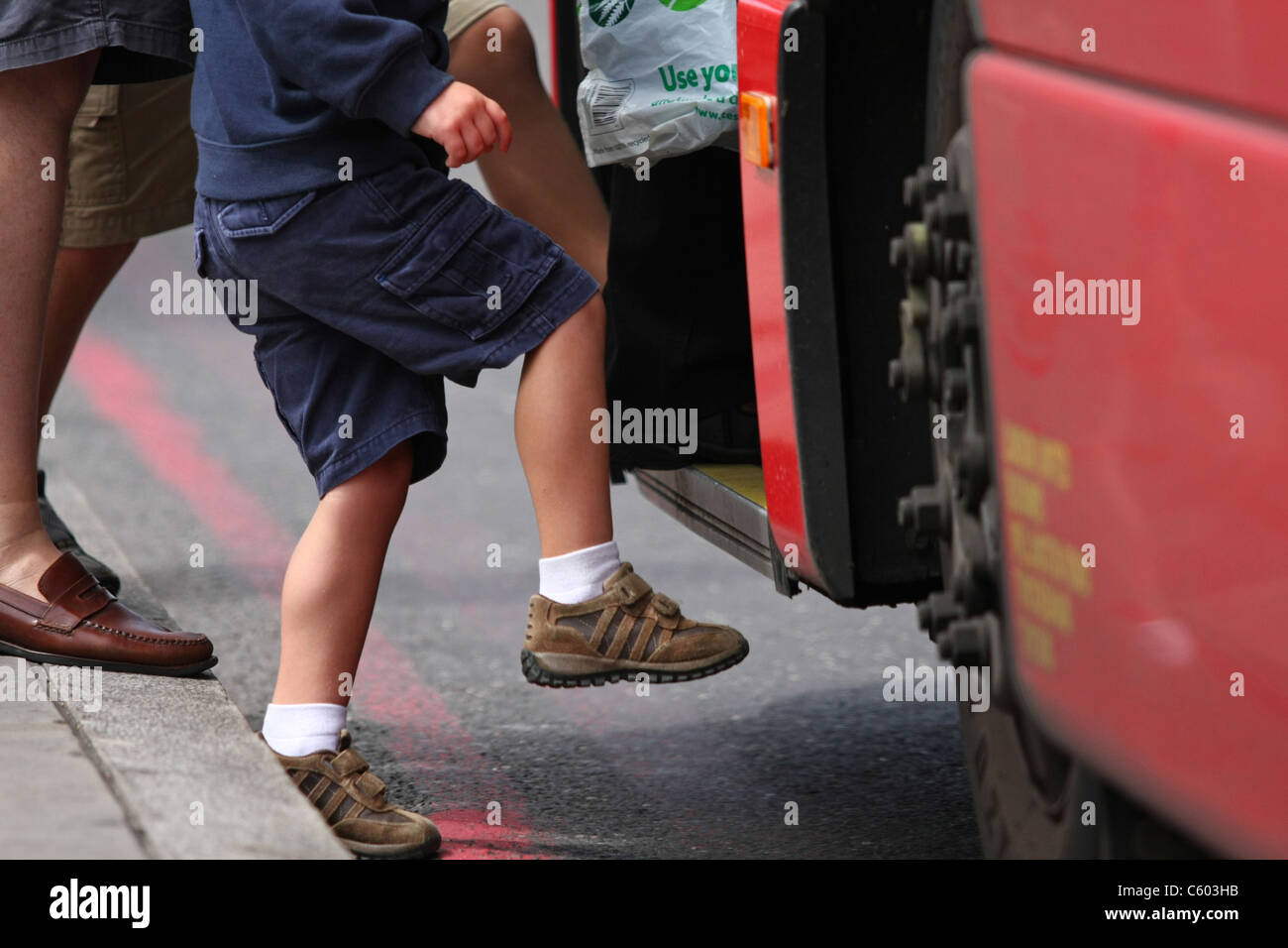 A child getting on a red London bus at a bus stop Stock Photo - Alamy