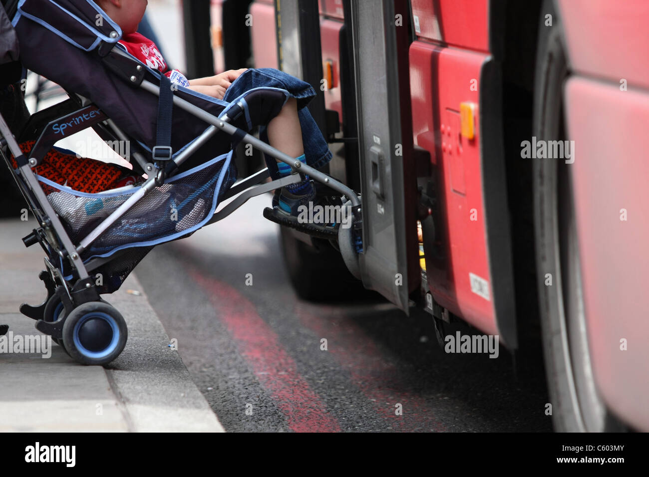 a pushchair with a child being offloaded from a red London bus Stock ...