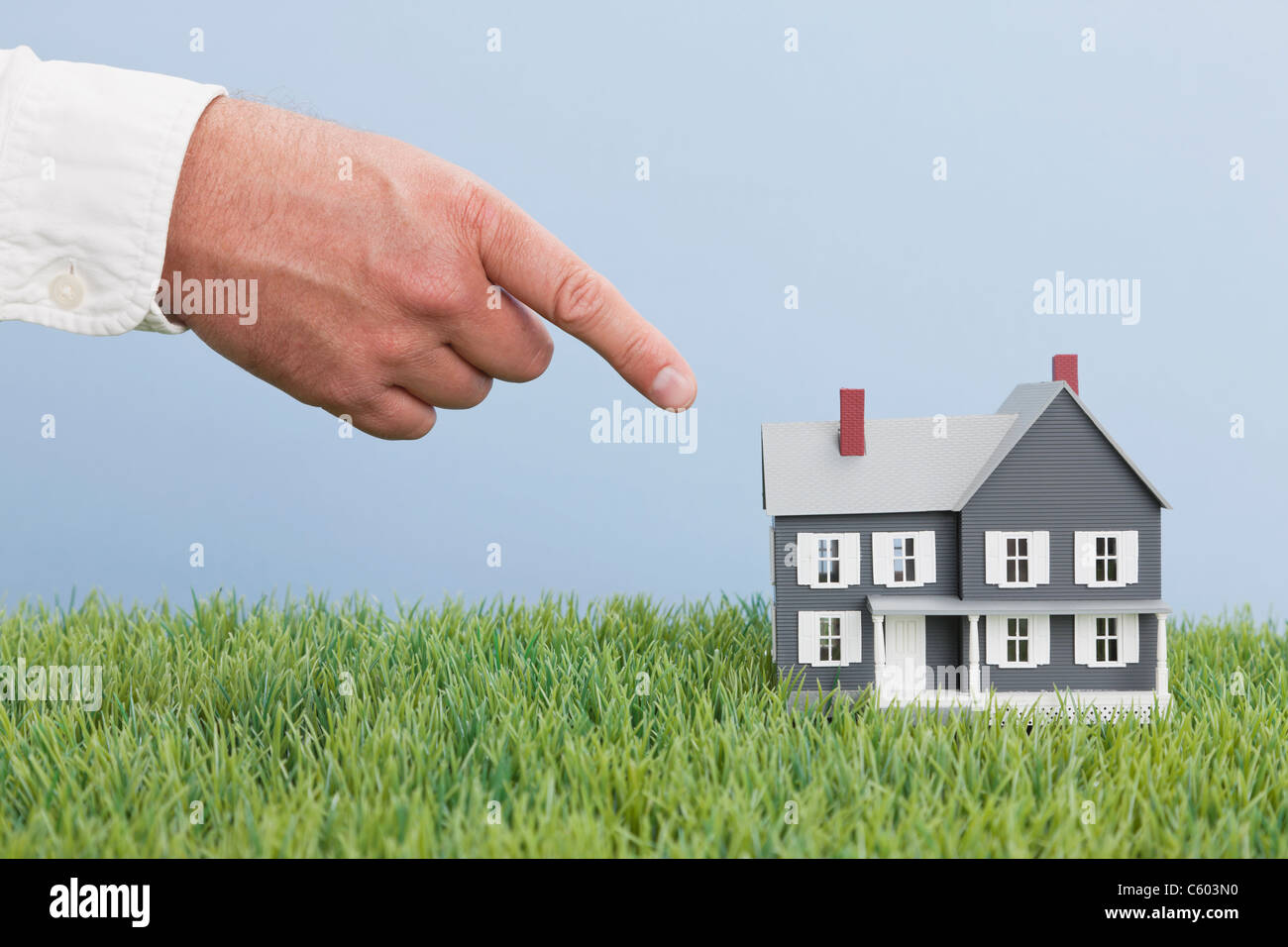 Close up of man's hand pointing on model house Stock Photo - Alamy