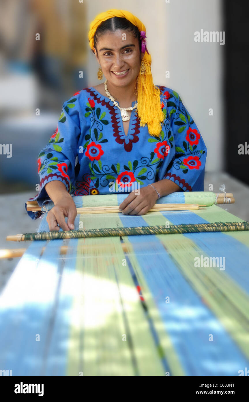 Beautiful woman in traditional dress weaving Stock Photo - Alamy