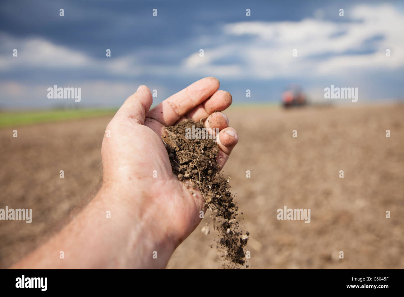 USA, Illinois, Metamora, hand holding dirt, ploughed field in ...