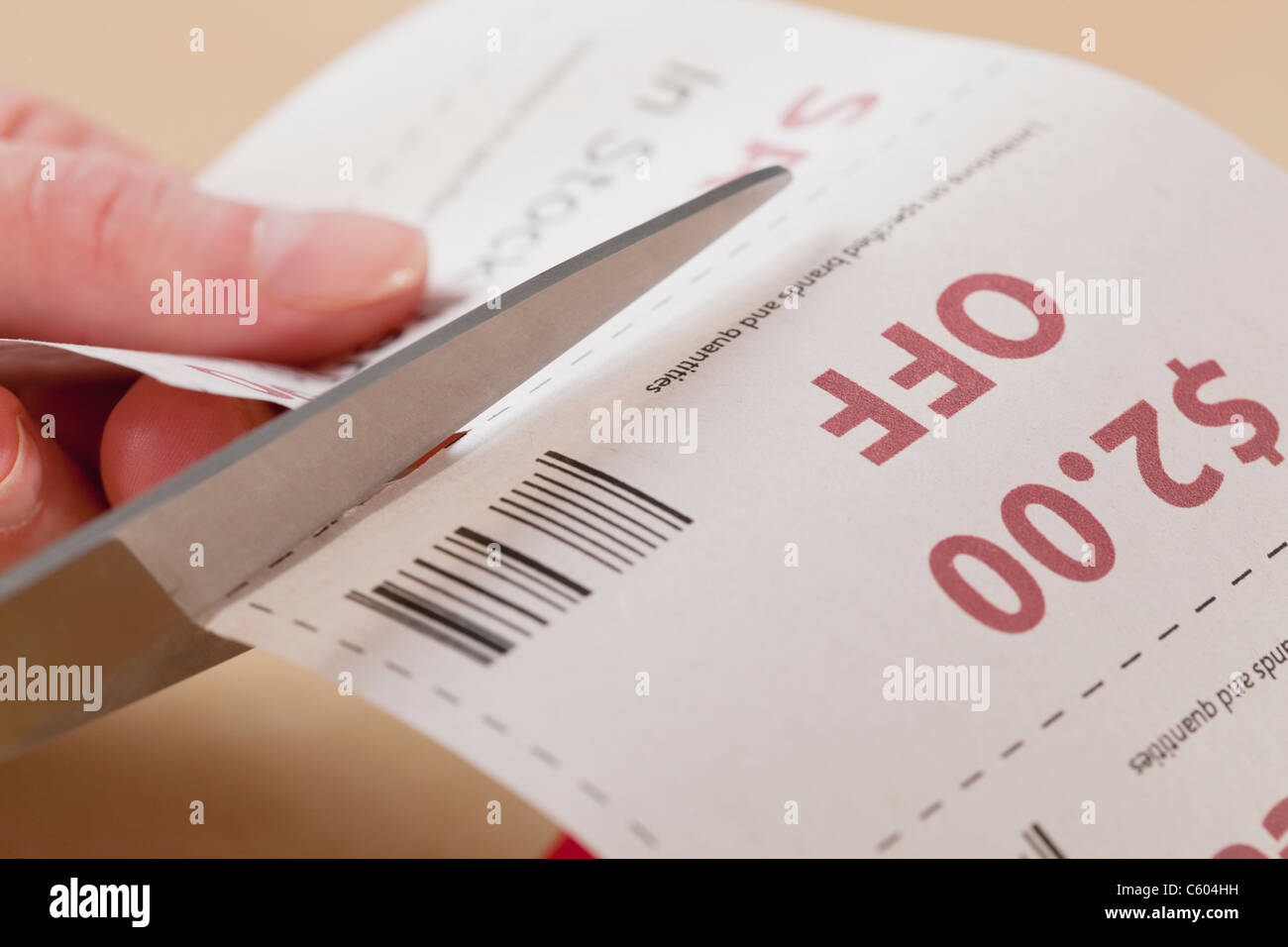 Hands cutting out coupon Stock Photo - Alamy