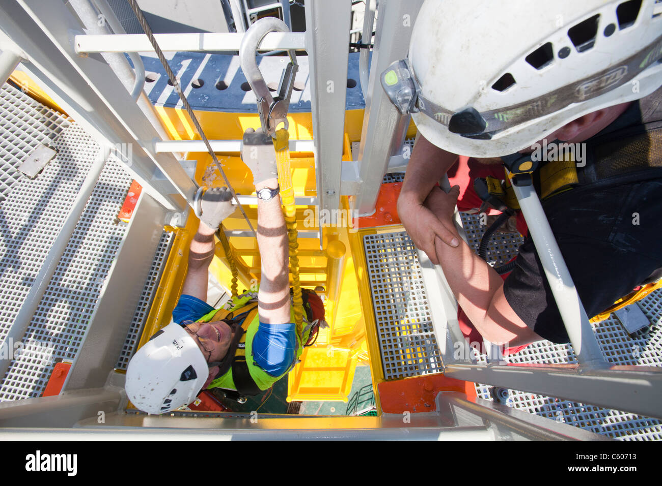 A worker climbs a transition piece, to fix the lifting hooks into place ...