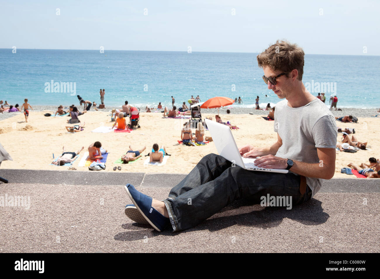 Man on laptop computer, Promenade des Anglais, Nice, France Stock Photo ...