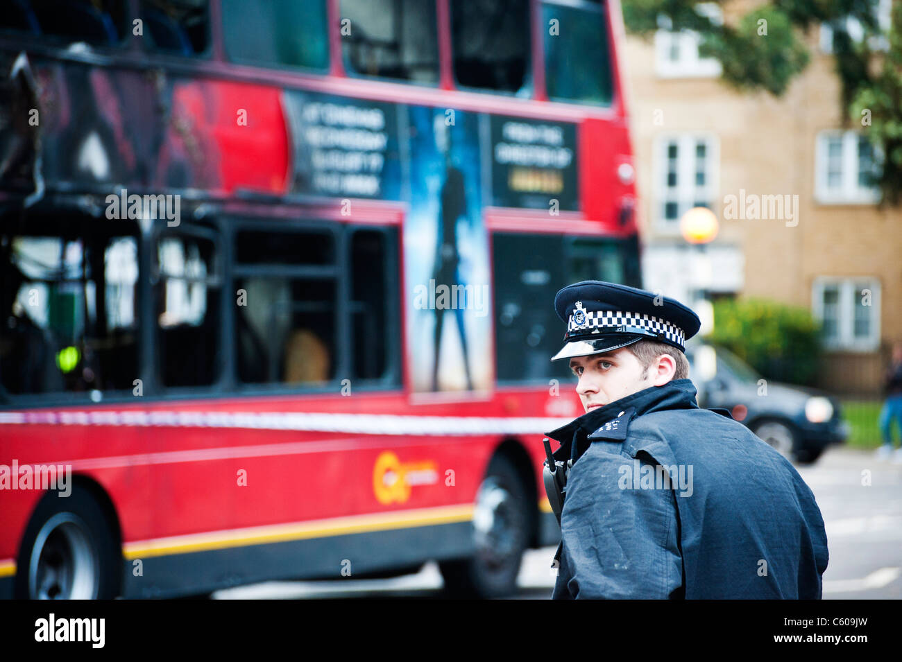 Police man guarding a bus during the London Riots Stock Photo - Alamy