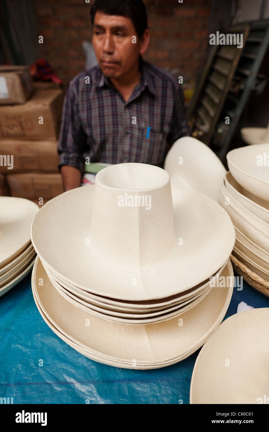 A hat maker sits behind his products in the central market of Cajamarca ...