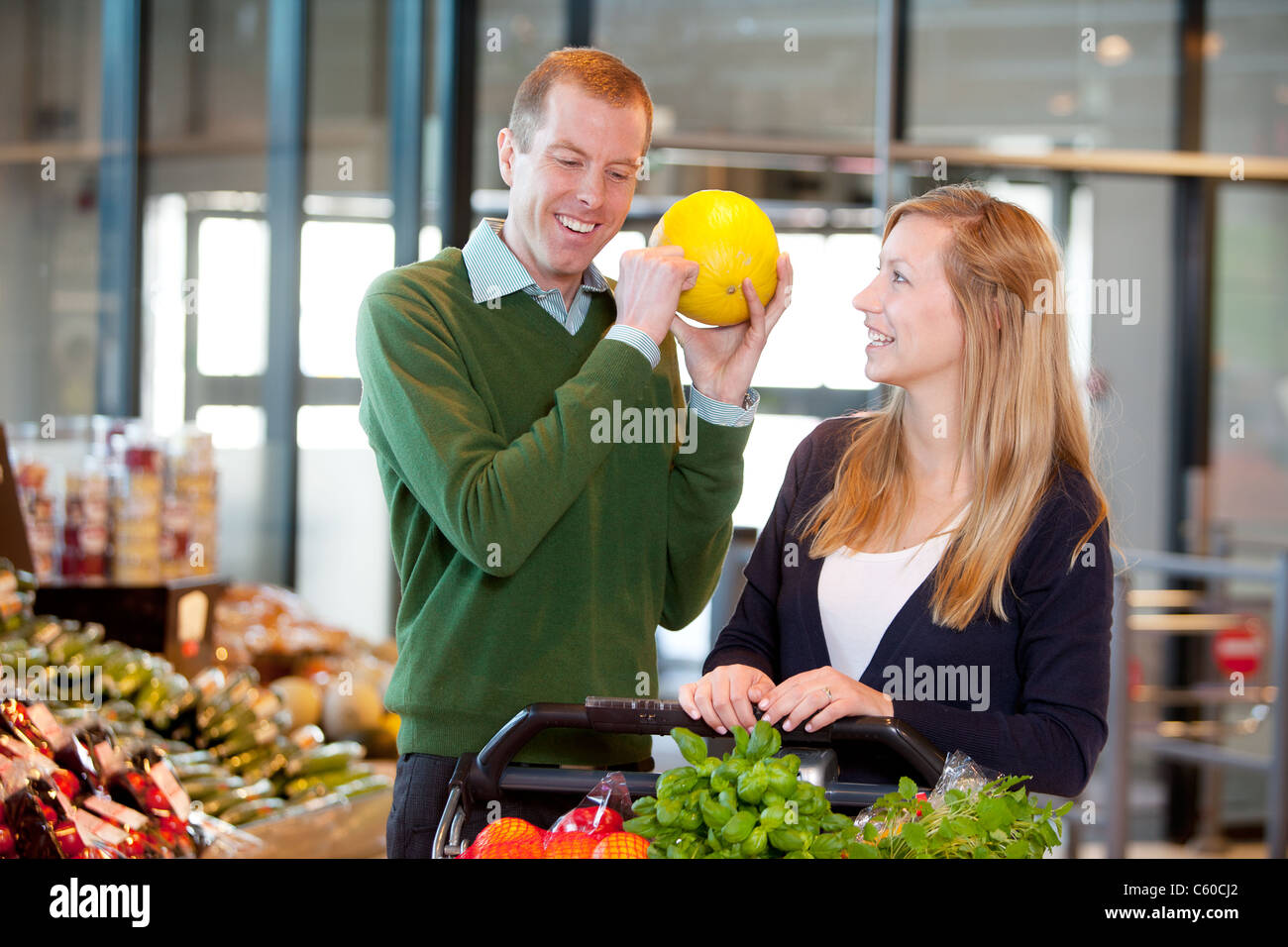 A man knocking on a melon to check if it is ripe Stock Photo - Alamy