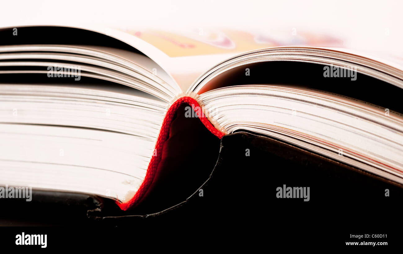 Opened book with red cover on dark background Stock Photo - Alamy