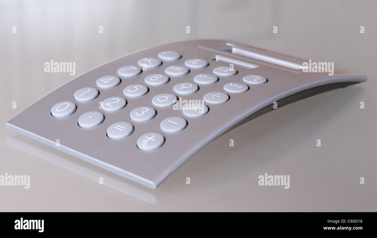 Gray calculator with round keys which runs on solar power on a glass ...