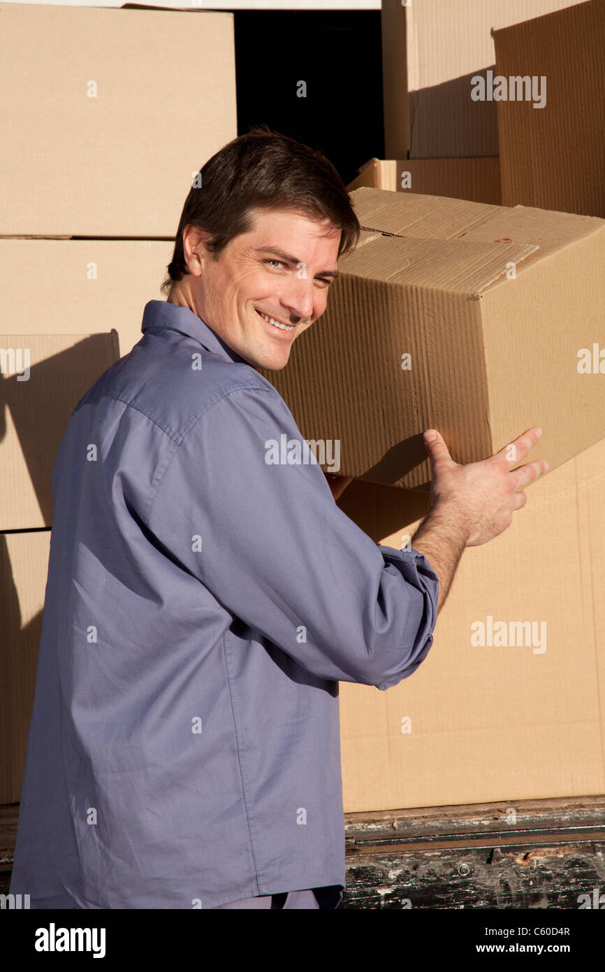 A portrait of a happy mover, moving cardboard boxes Stock Photo - Alamy