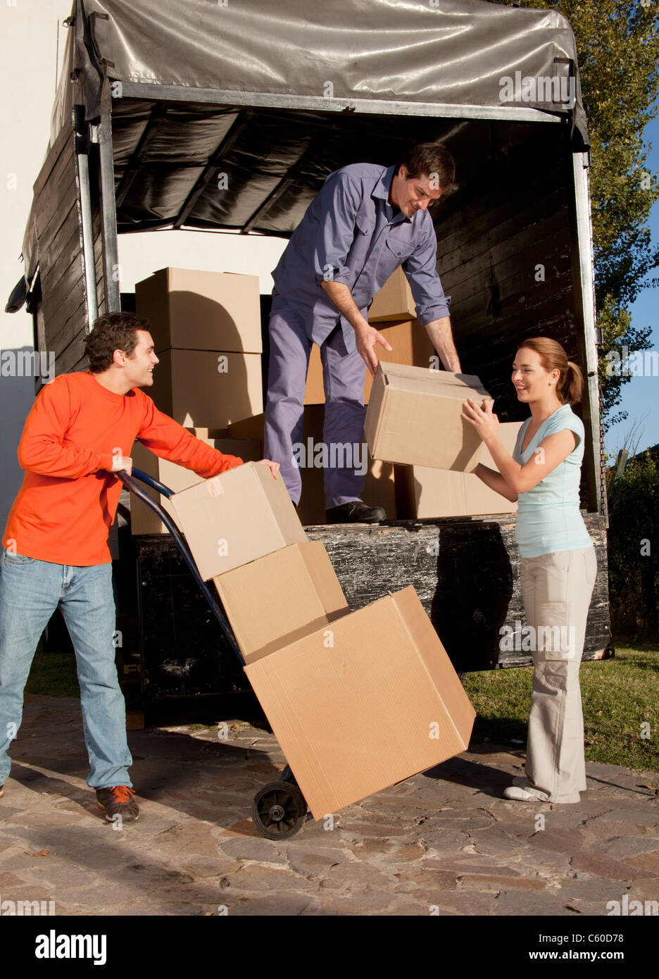 A group of people moving boxes from a trailer Stock Photo - Alamy