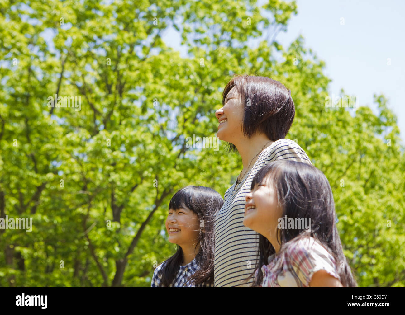 Mother and daughters smiling Stock Photo - Alamy