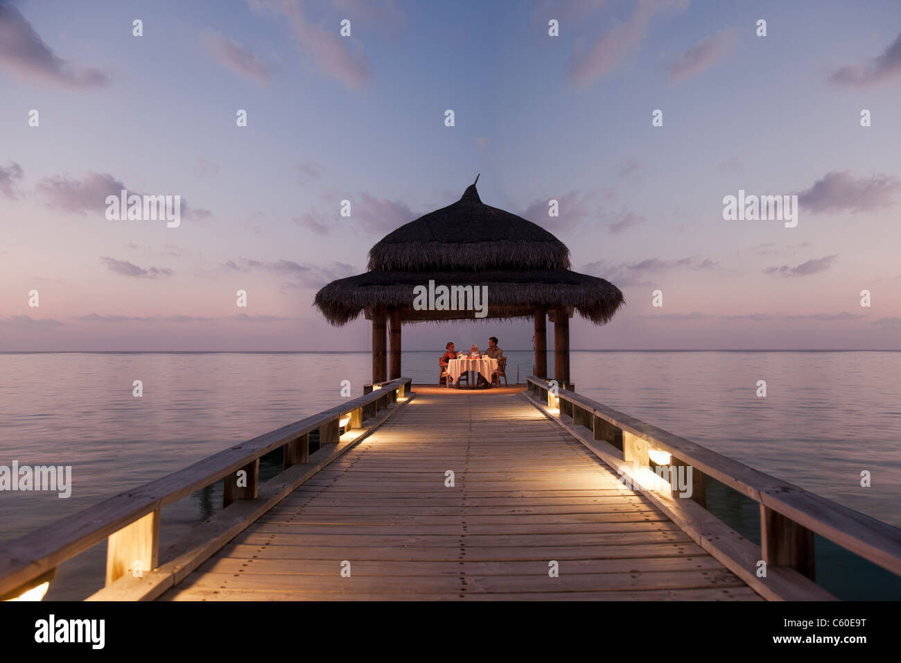 Couple eating on tropical dock Stock Photo - Alamy