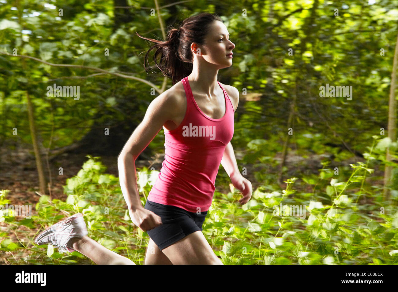 Woman running in forest Stock Photo - Alamy