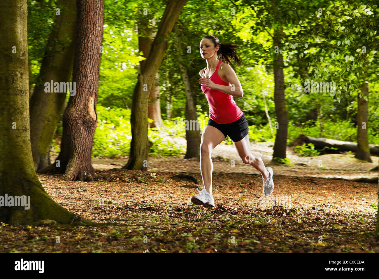 Woman running in forest Stock Photo - Alamy
