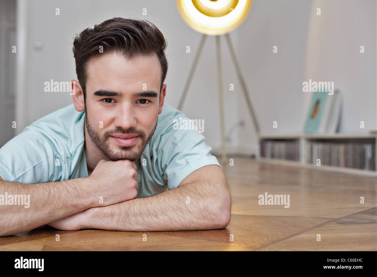 Smiling man laying on floor Stock Photo - Alamy