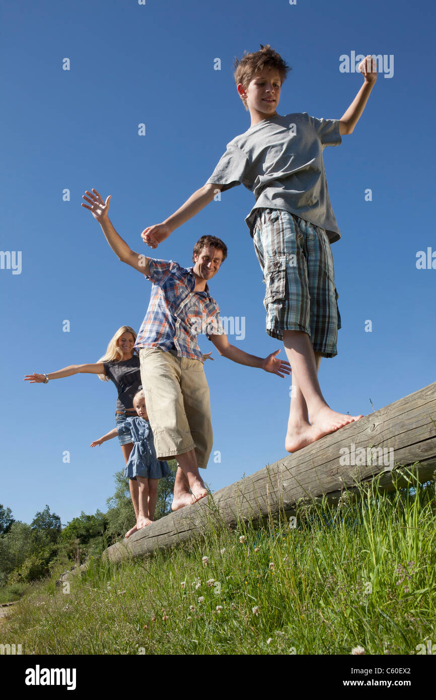 Family balancing on log outdoors Stock Photo - Alamy