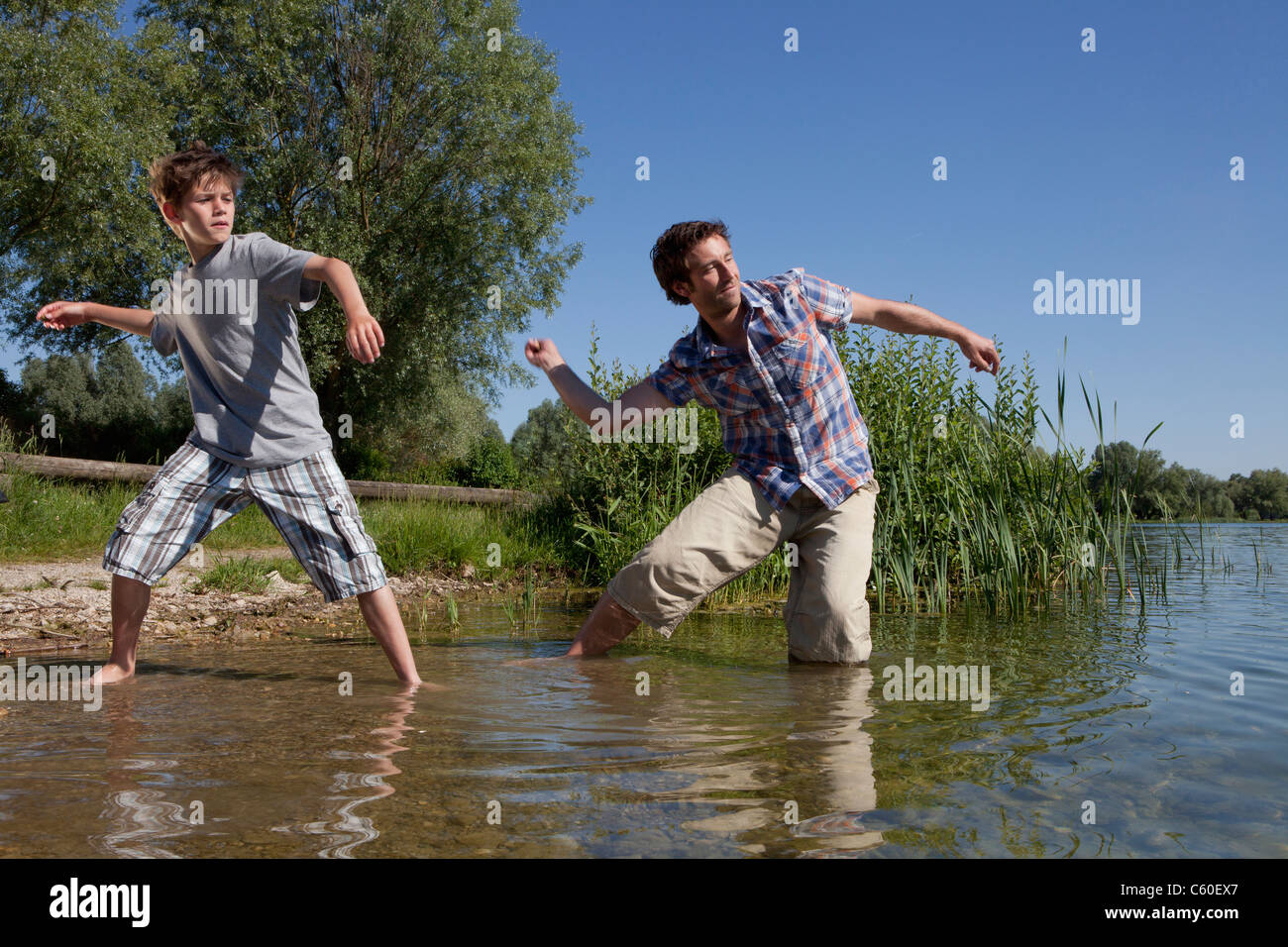 Father and son skipping rocks on lake Stock Photo - Alamy