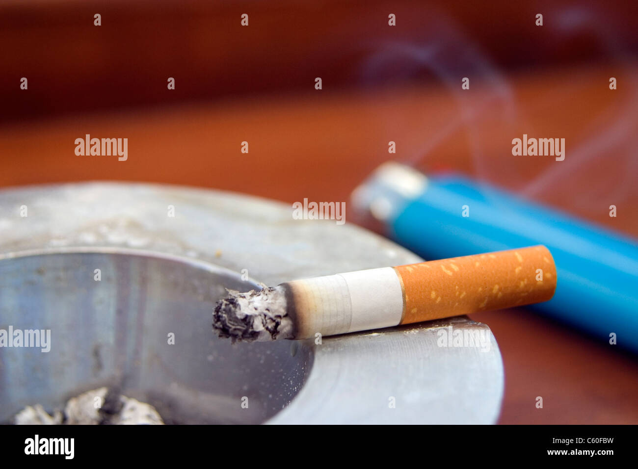 Burning cigarette smoking on ashtray Stock Photo - Alamy